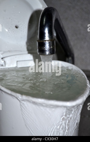 overflowing with water kettle / jug under tap / faucet Stock Photo - Alamy