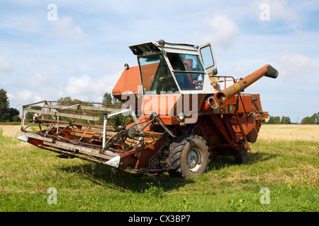 Old grain harvester still working in the field Stock Photo - Alamy