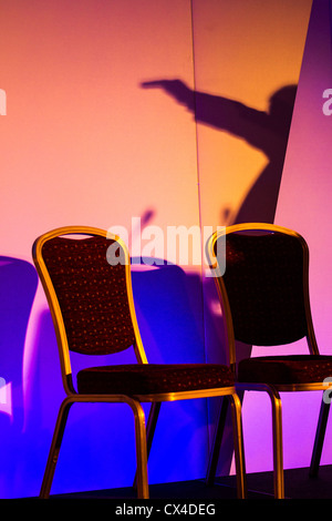 A menacing shadow behind two empty chairs threatens violence Stock ...