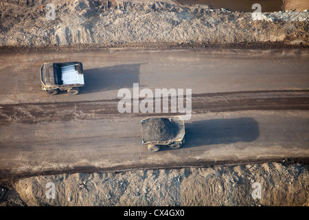 Massive dump trucks loaded with tar sand in a mine north of Fort ...