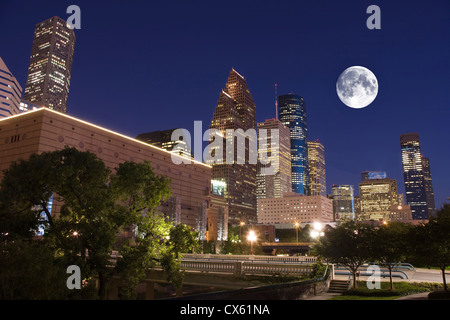 Houston downtown skyline at night with full moon as seen from path and ...