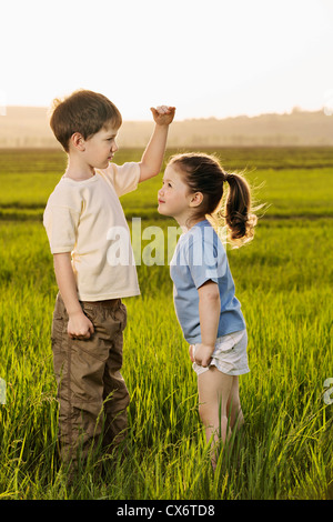 two girls measuring their heights in classroom Stock Photo - Alamy