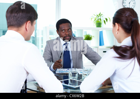 Portrait of serious boss talking to his employees Stock Photo - Alamy