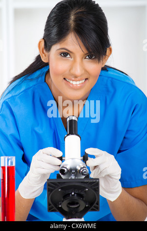 Examining the sample. an attractive young female scientist examining a beaker filled with liquid ...