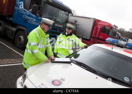 British traffic Police Officer checking on long-distance lorry drivers ...