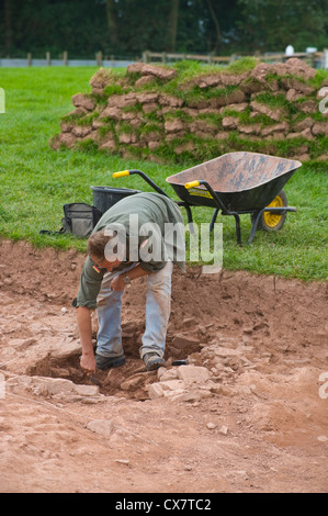 Archaeologist digging with trowel at a prehistoric neolithic site on ...