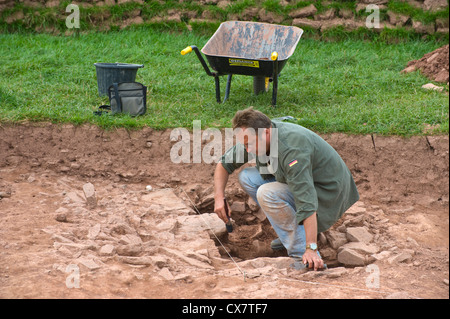 Archaeologist digging with trowel at a prehistoric neolithic site on ...