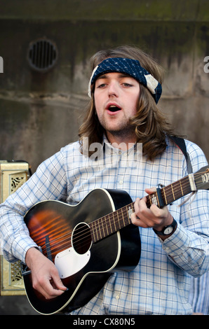 Singer/guitarist busking with his band during the Edinburgh Festival ...
