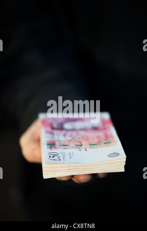 UK Pound banknotes and hand holding Post Office account card used for ...