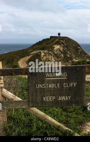 Danger sign warning of unstable cliffs in English and Portuguese Stock ...
