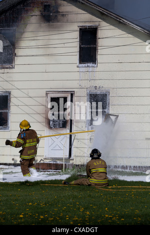 Volunteer firefighters fighting a house fire Stock Photo - Alamy