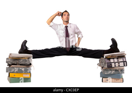 Businessman doing splits over stack of files Stock Photo - Alamy