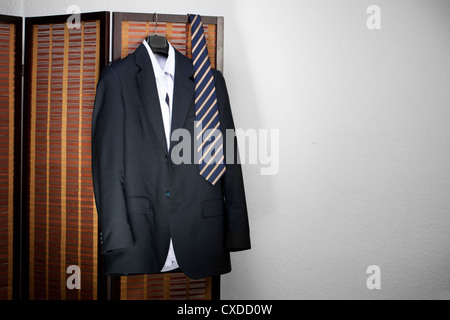 Mens suit hanging on hangers Stock Photo - Alamy