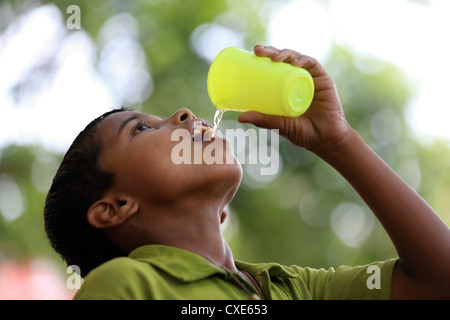 Indian school girl drinking water from a plastic glass Stock Photo: 73732498 - Alamy