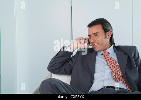 Slacker man talking on the phone while eating at work / modern office ...