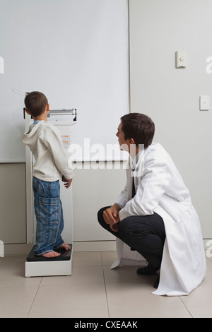 A physician weighing a child in pediatric clinic Stock Photo - Alamy
