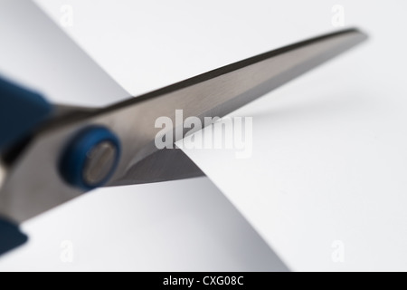 A pair of scissors cutting snipping a piece of paper Stock Photo - Alamy