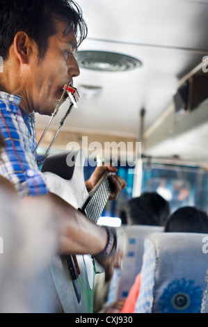 An indonesian man busking by singing in the bus, asia scene Stock Photo ...