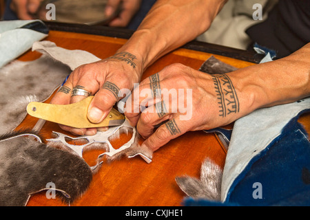 Inuit woman demonstrates seal skin cutting and sewing techniques Stock ...