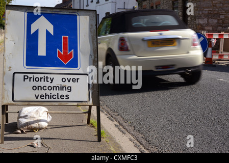 Car passing a "Give way to oncoming vehicles" sign in Blackpool ...