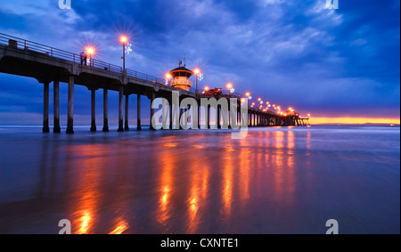 The Huntington Beach Pier and surfers at sunset. Huntington Beach ...