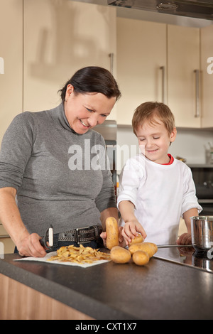 Mother and son peeling potatoes Stock Photo - Alamy