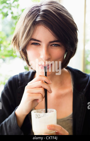 Woman drinking coffee through a straw Stock Photo - Alamy