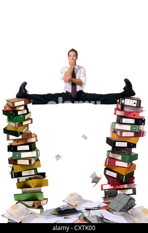 Businessman doing splits over stack of files Stock Photo - Alamy