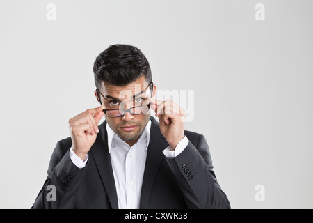 Portrait of man peering over glasses Stock Photo - Alamy