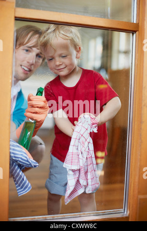Happy family cleaning windows Stock Photo - Alamy