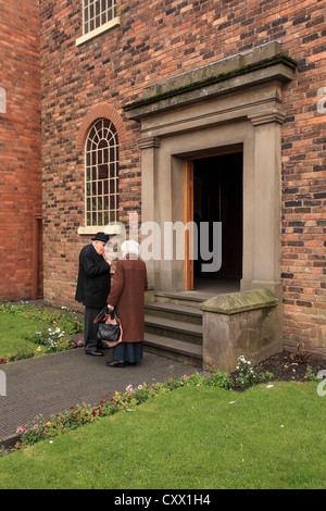 Church goers in old fashioned Victorian clothes outside a typical ...