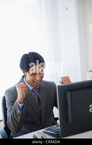 Middle Eastern businessman cheering at desk Stock Photo - Alamy