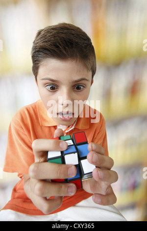 Confused looking boy with a magic cube Stock Photo - Alamy