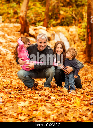 Happy parents with daughter in autumn park, family portrait amid fall ...