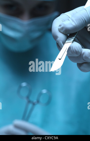 Doctor's Hand Holding Surgical Scalpel in front of Woman's Face Stock ...
