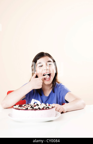 Girl nibbling from a cake Stock Photo - Alamy