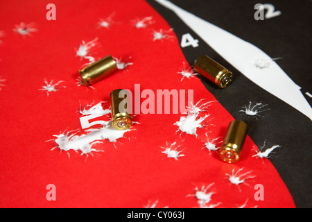 human shaped target ridden with bullet holes and 9mm empty shell ...