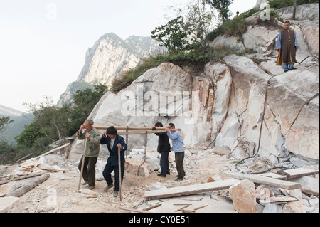 Workers lifting heavy rocks at the San Huang Zhai Monastery on Song ...