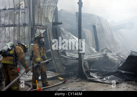 A woman firefighter at the scene of an industrial building fire ...