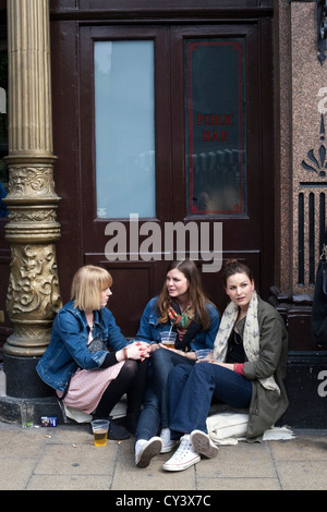 Customers sit outside a pub in Danson Stables, in the summer sun ...