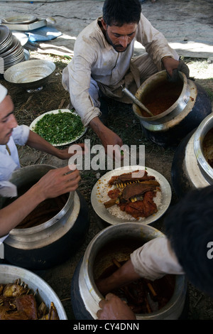 Wazas, traditional Kashmiri cooks, serve Wazwan onto a Trami (plate) at ...