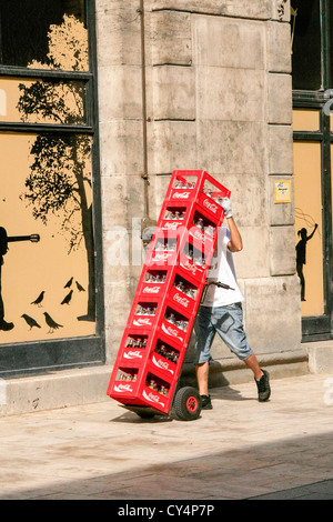 Coke delivery man wheels crates of the fizzy drink along the streets of ...