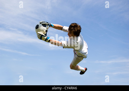 Soccer goalkeeper diving to block ball Stock Photo - Alamy