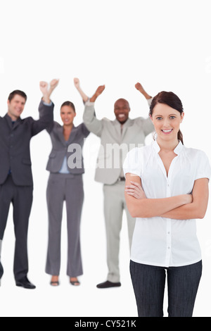 Smiling businesswoman with cheering co-workers behind her Stock Photo ...