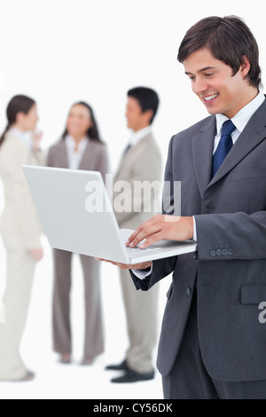 Salesman with notebook and team behind him Stock Photo - Alamy