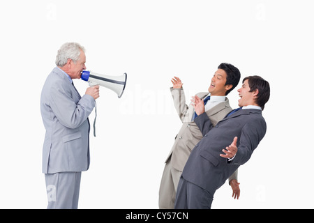 Senior businessman with megaphone yelling at his employees against a ...