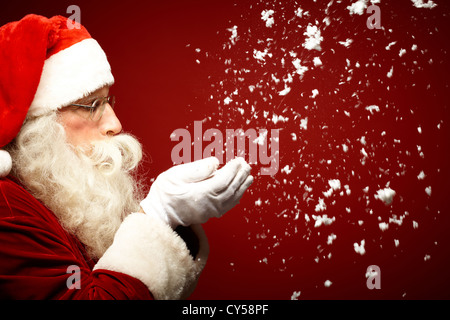 Photo of Santa Claus blowing snow and looking at it Stock Photo - Alamy