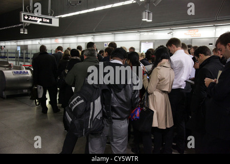 Tube commuters queue to get on the Underground at Canary Wharf Station ...