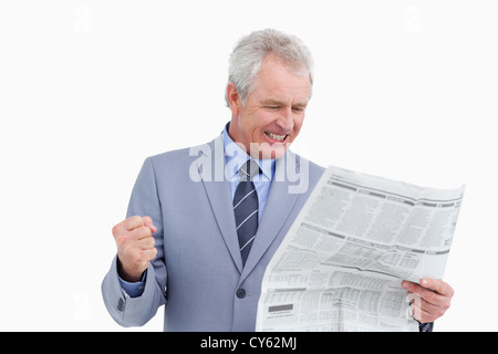 Mature tradesman cheering about news paper article Stock Photo - Alamy