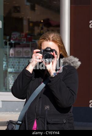Woman taking a photo with an SLR camera Stock Photo - Alamy